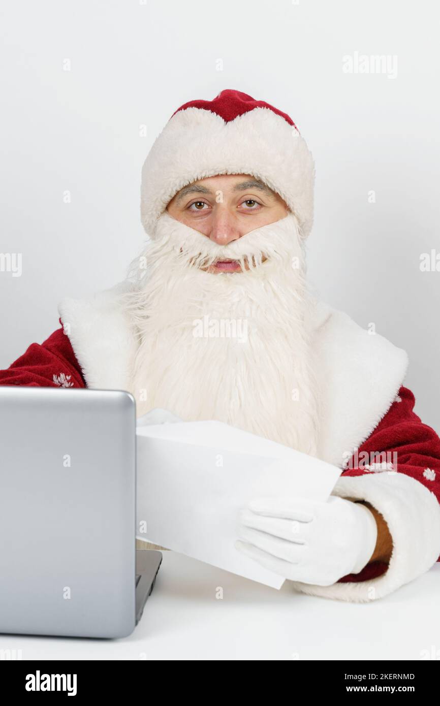 Christmas and New Year concept. Santa Claus is sitting at his desk and ...