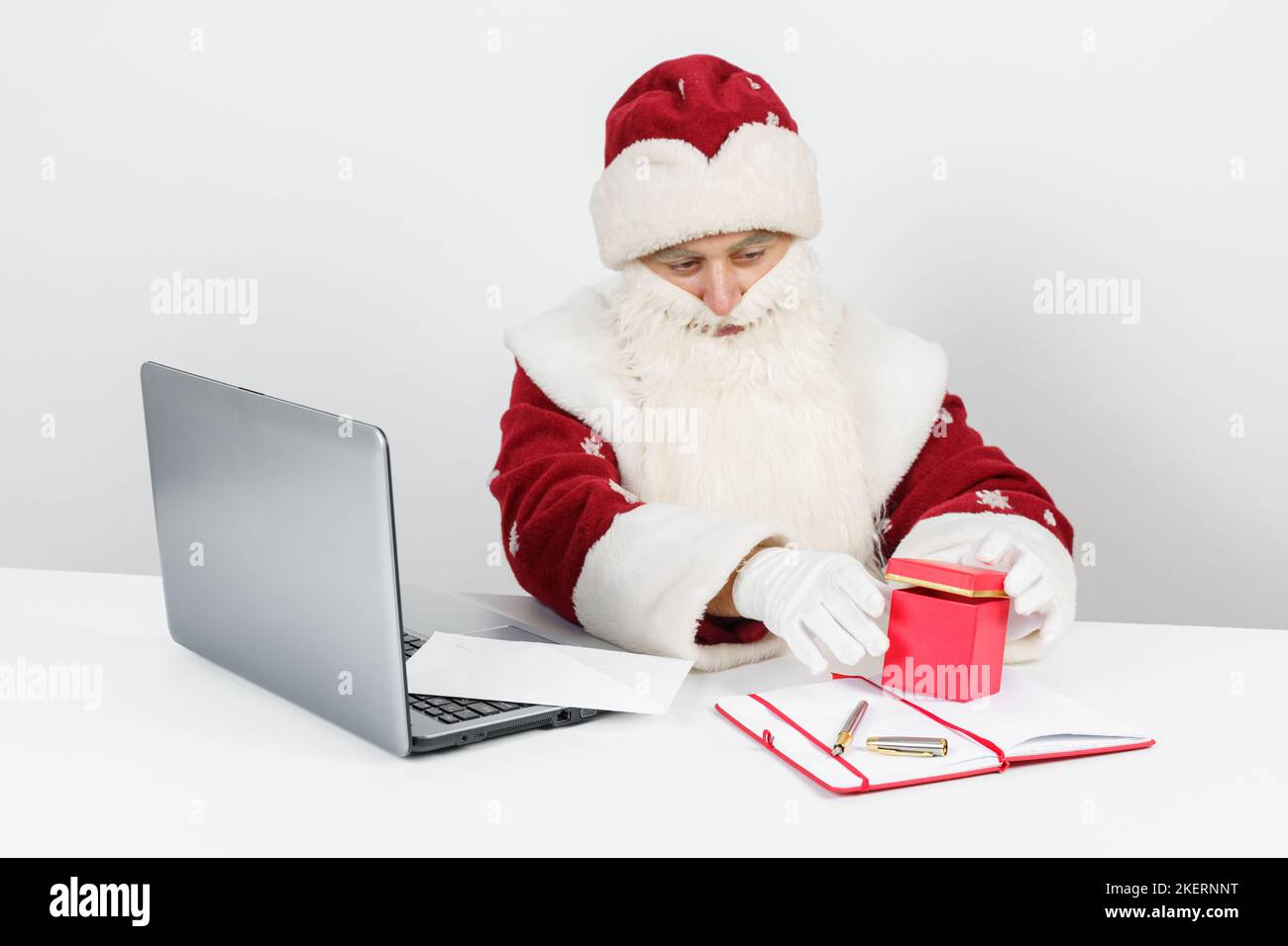 Christmas and New Year concept. Santa Claus is sitting at his desk and ...