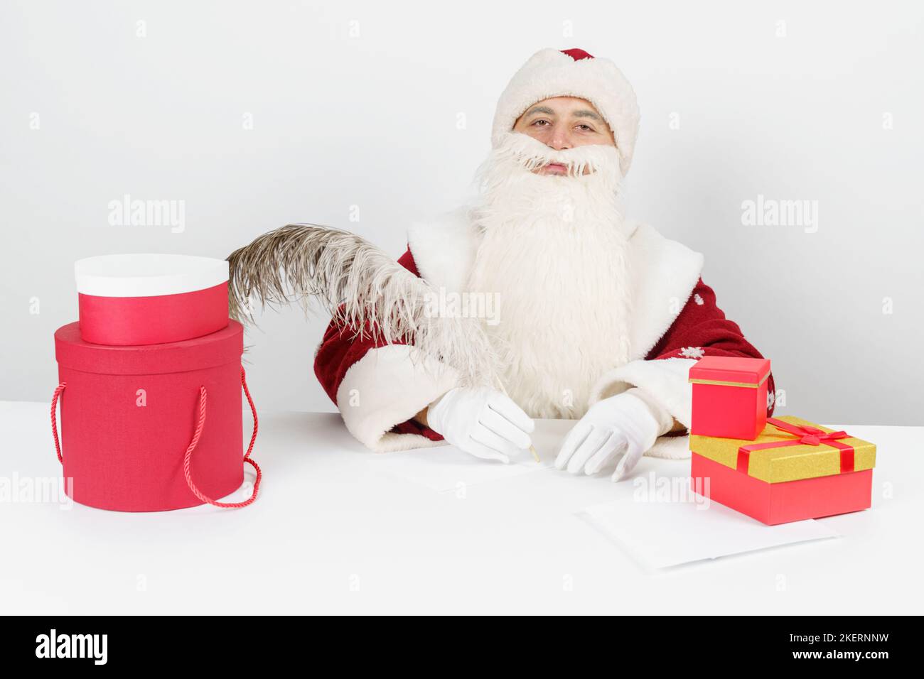 Christmas and New Years concept. Santa Claus sits at his desk and ...