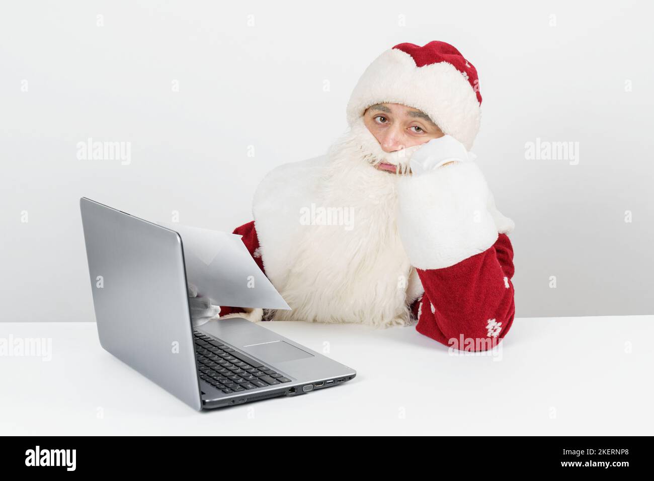 Christmas and New Year concept. Santa Claus is sitting at his desk and ...
