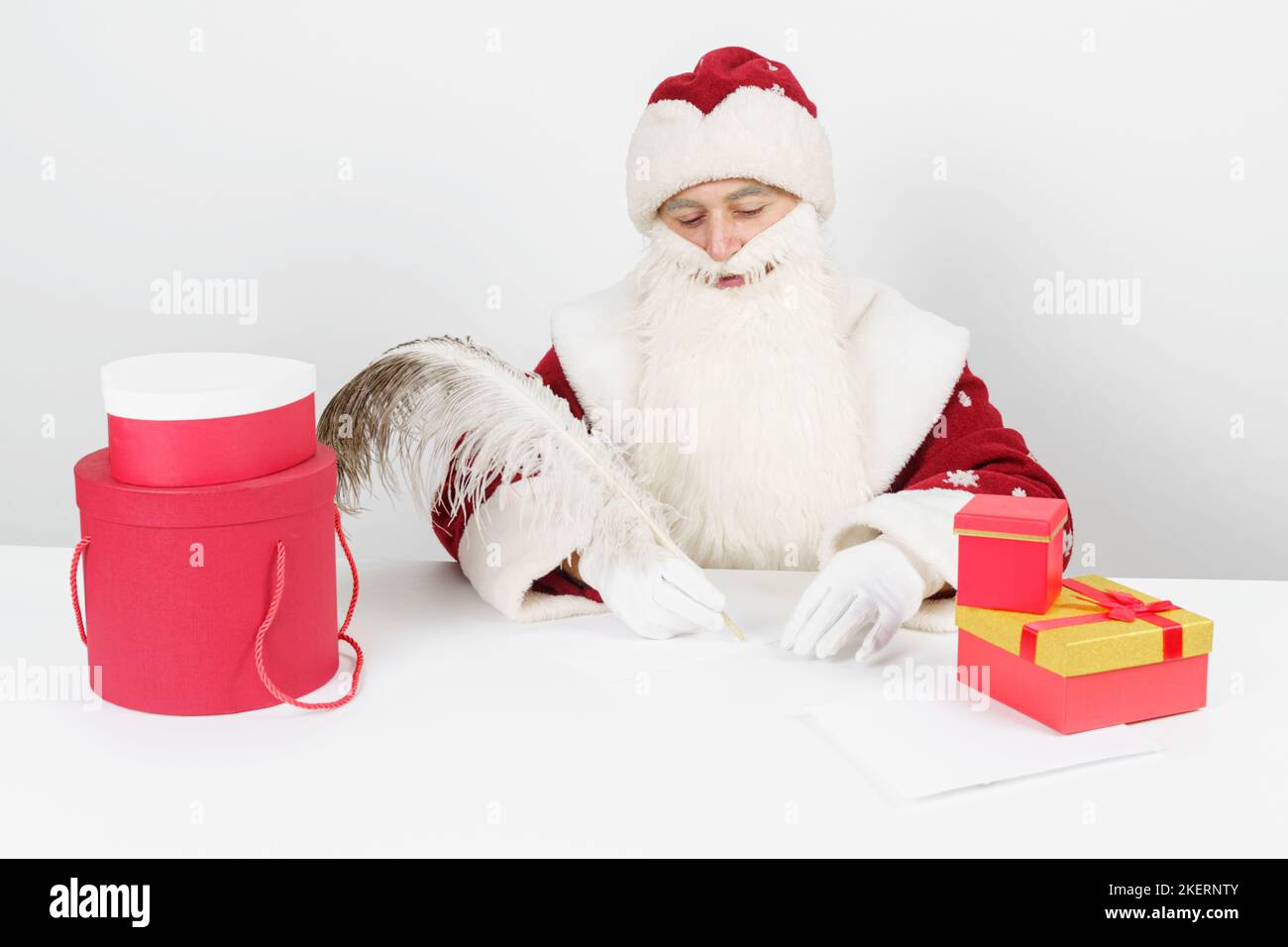 Christmas and New Years concept. Santa Claus sits at his desk and ...