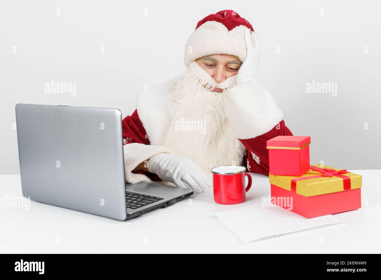 Christmas and New Years concept. Tired Santa Claus sits at his desk ...