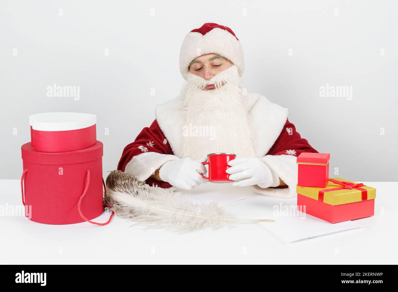 Christmas and New Years concept. Santa Claus sits at his table and ...