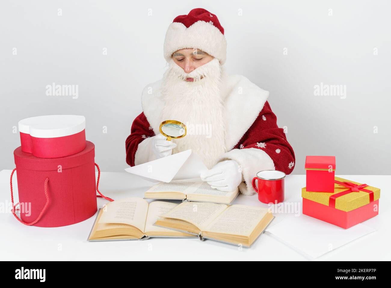 Christmas and New Years concept. Tired Santa Claus sits at the table ...