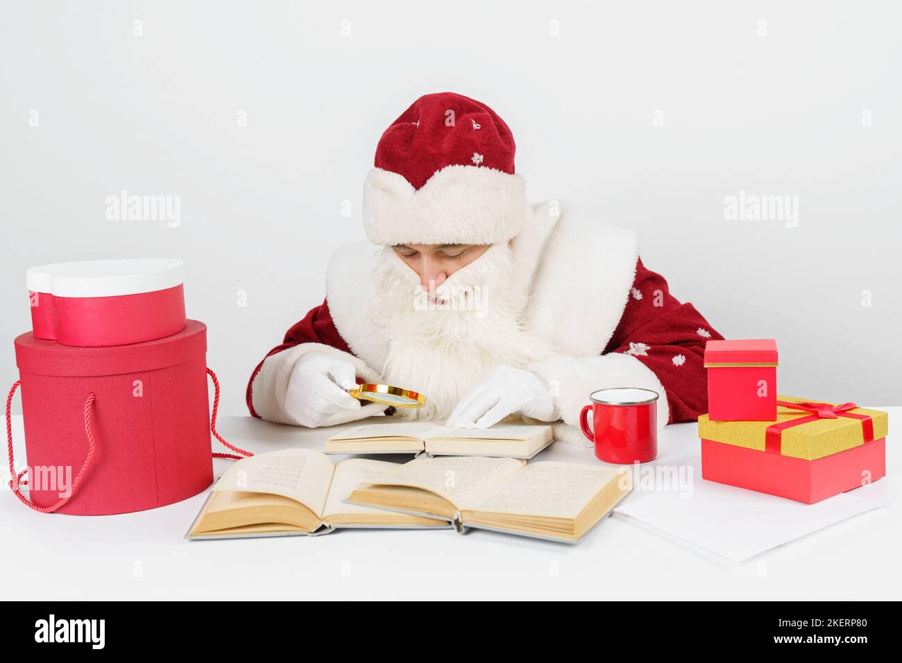 Christmas and New Years concept. A tired Santa Claus sits at a table ...