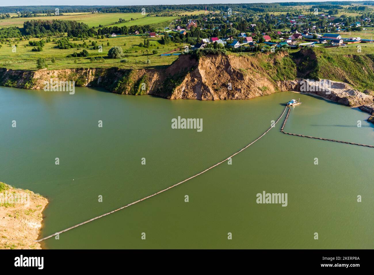 Sand mining in a flooded sand pit with a floating dredger, aerial view ...