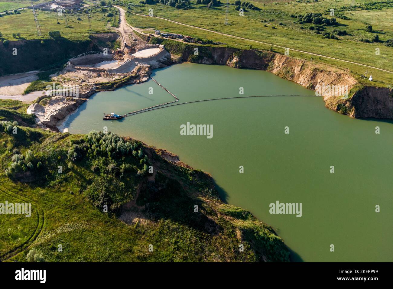 Sand mining in a flooded sand pit with a floating dredger, aerial view ...