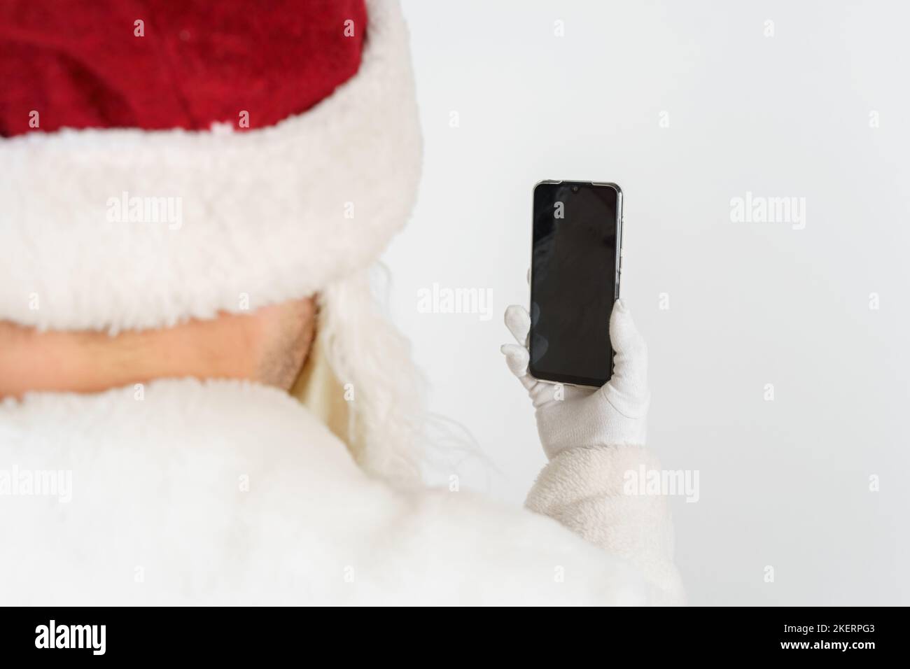 Christmas and New Years concept. Santa Claus holds a mobile phone in ...