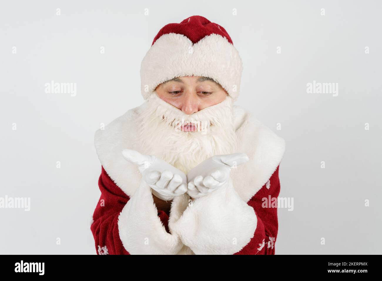 Christmas and New Years concept. Santa Claus blows off the palm ...