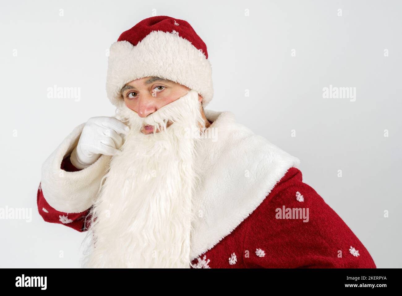 New year and villain concept. Santa Claus straightens his mustache with ...