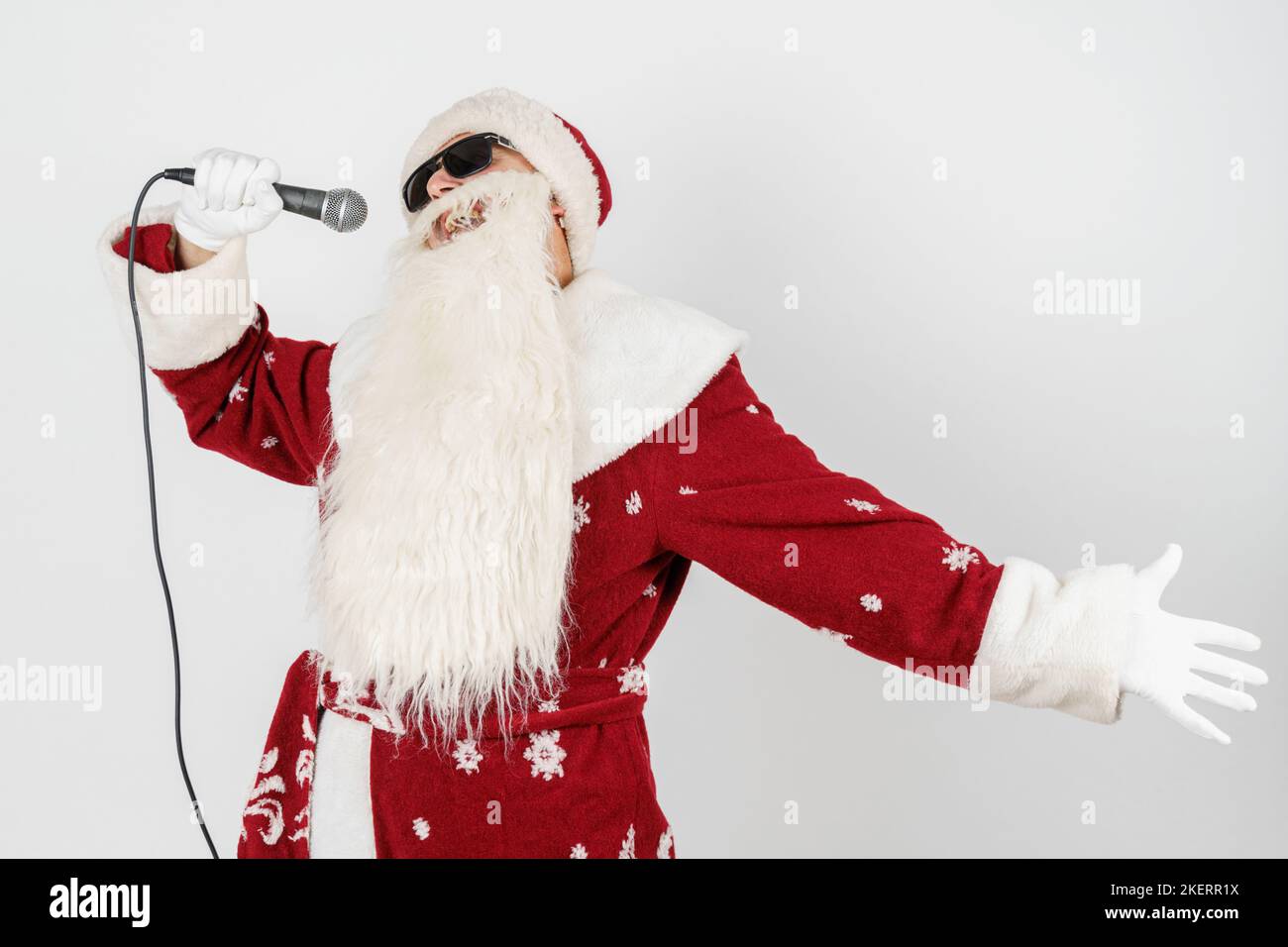 Holidays and christmas concept. Santa Claus sings with a microphone in ...