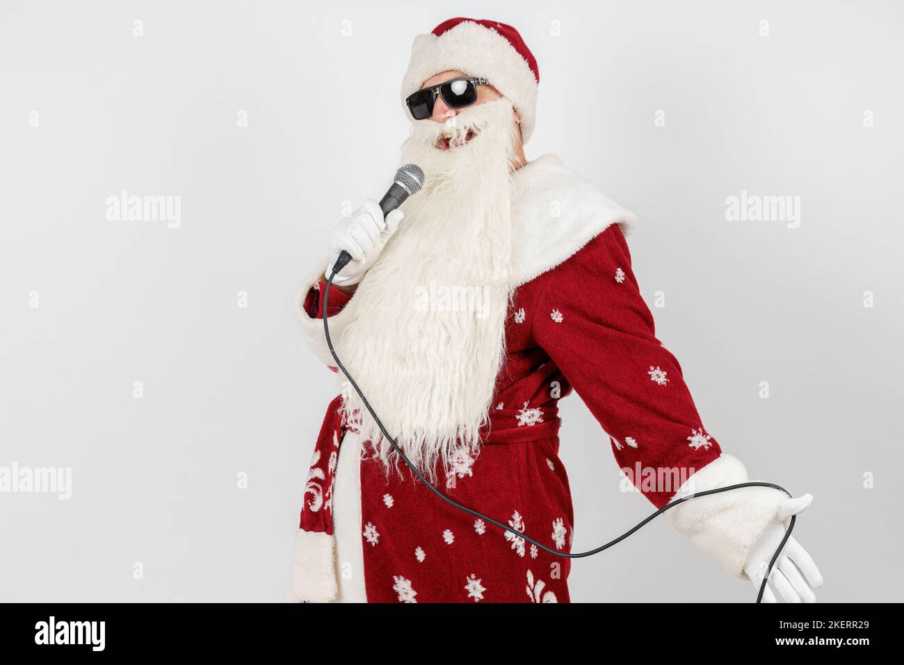 Holidays and christmas concept. Santa Claus sings with a microphone in ...