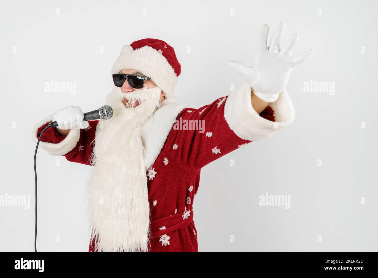 Holidays and christmas concept. Santa Claus sings with a microphone in ...