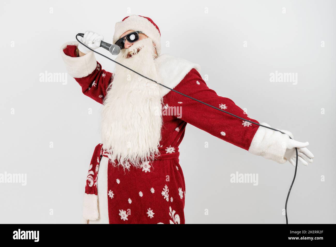 Holidays and christmas concept. Santa Claus sings with a microphone in ...