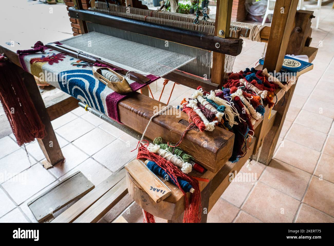 Woolen rugs made with natural dyes being woven on wooden foot-treadle ...