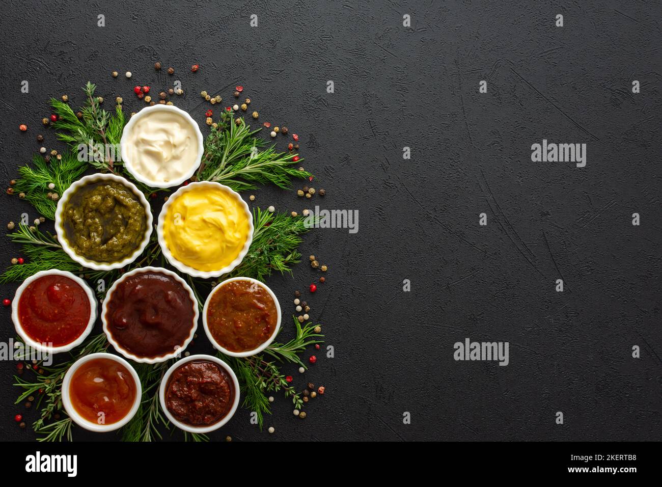 Different types of sauces in bowls with seasonings, rosemary and dill ...