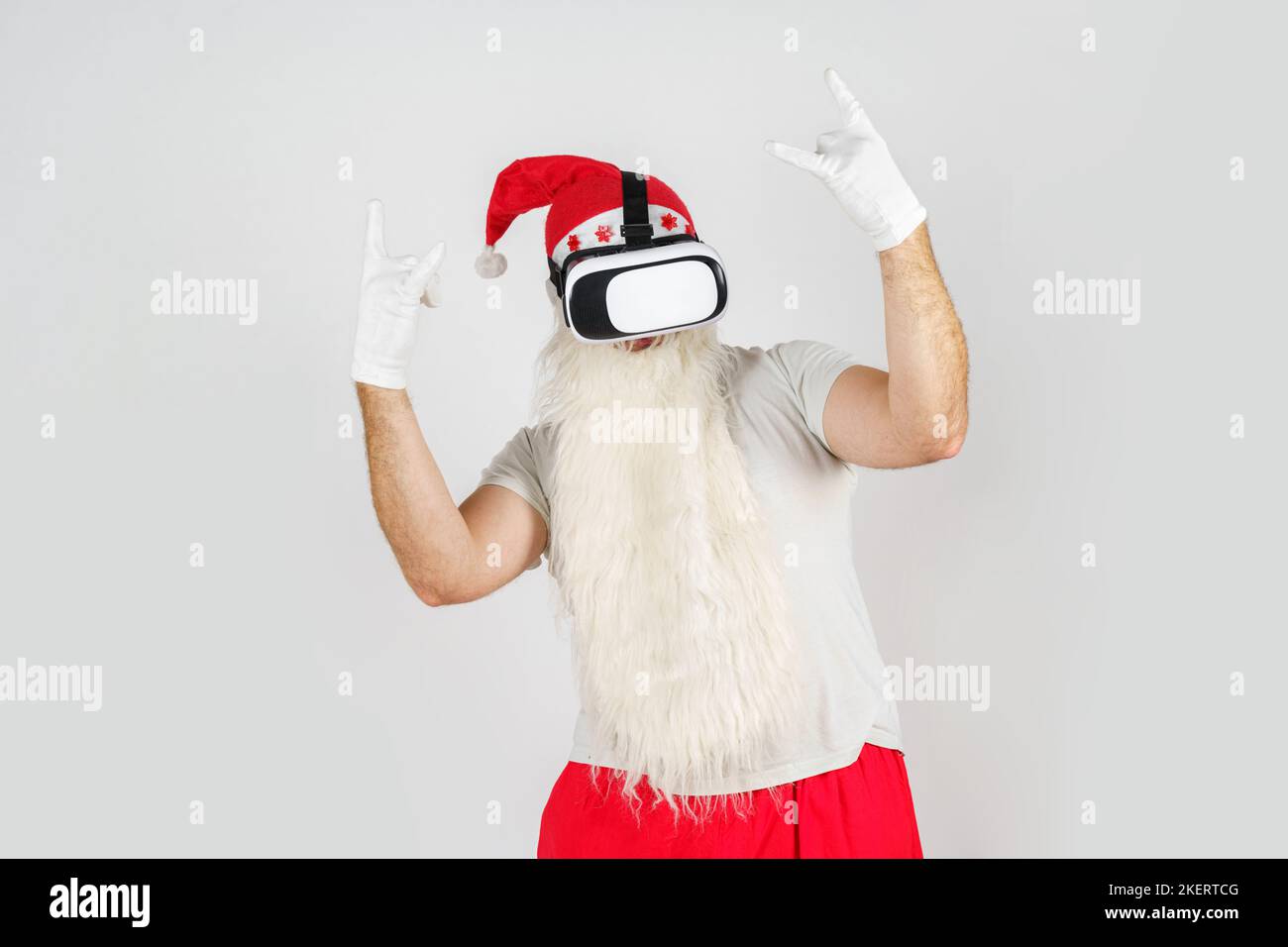 Christmas and New Years concept. Santa Claus in VR glasses plays with ...