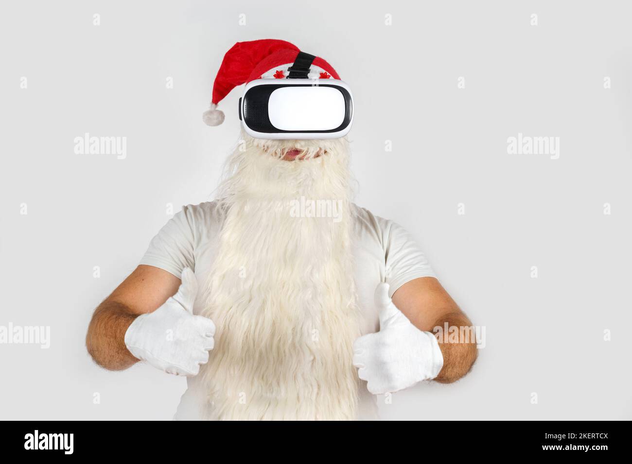 Christmas and New Years concept. Santa Claus in VR glasses plays with ...