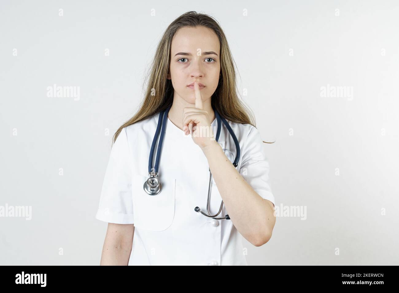 Medicine and health concept. A young woman doctor shows with a finger ...
