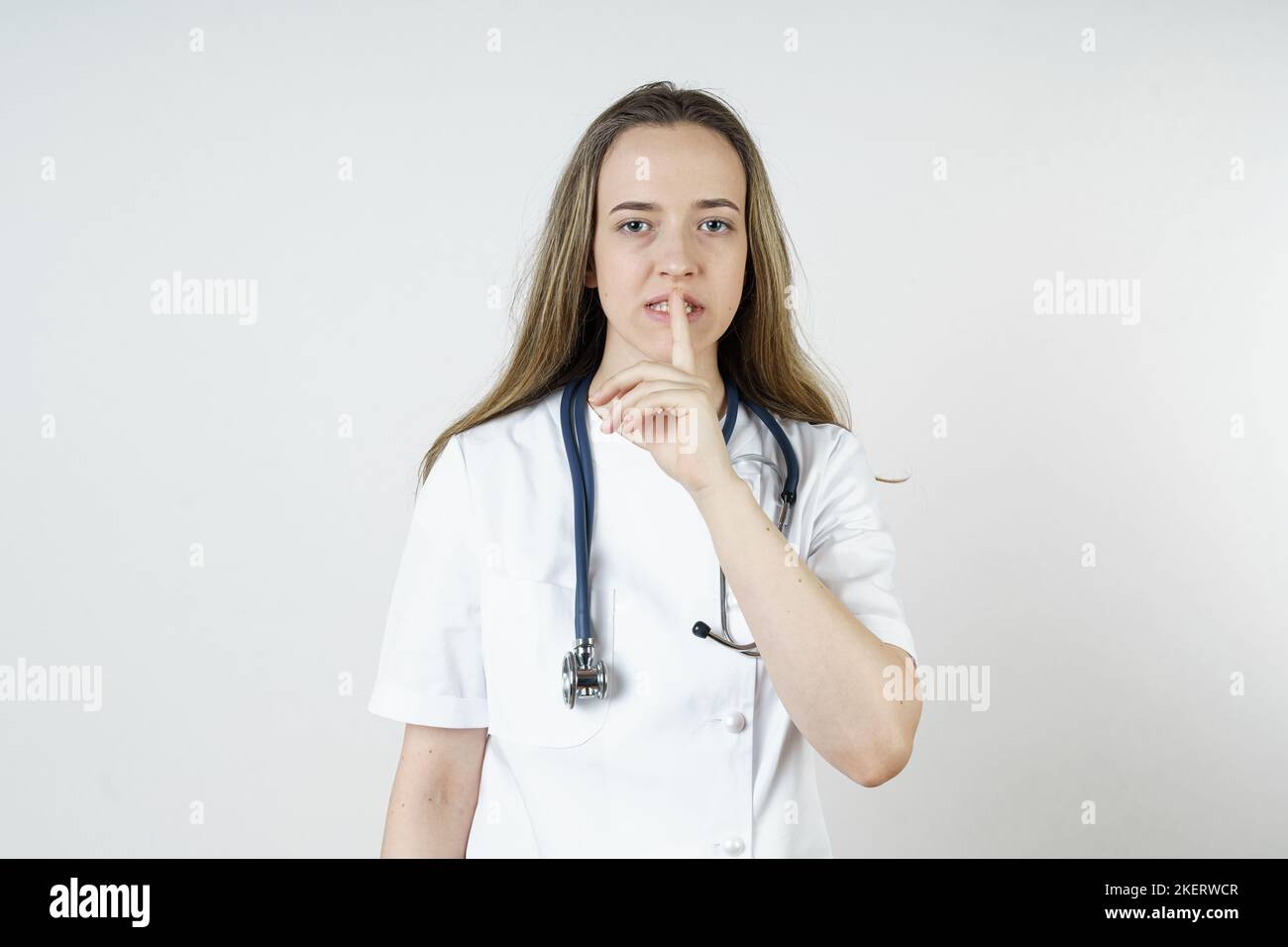 Medicine and health concept. A young woman doctor shows with a finger ...