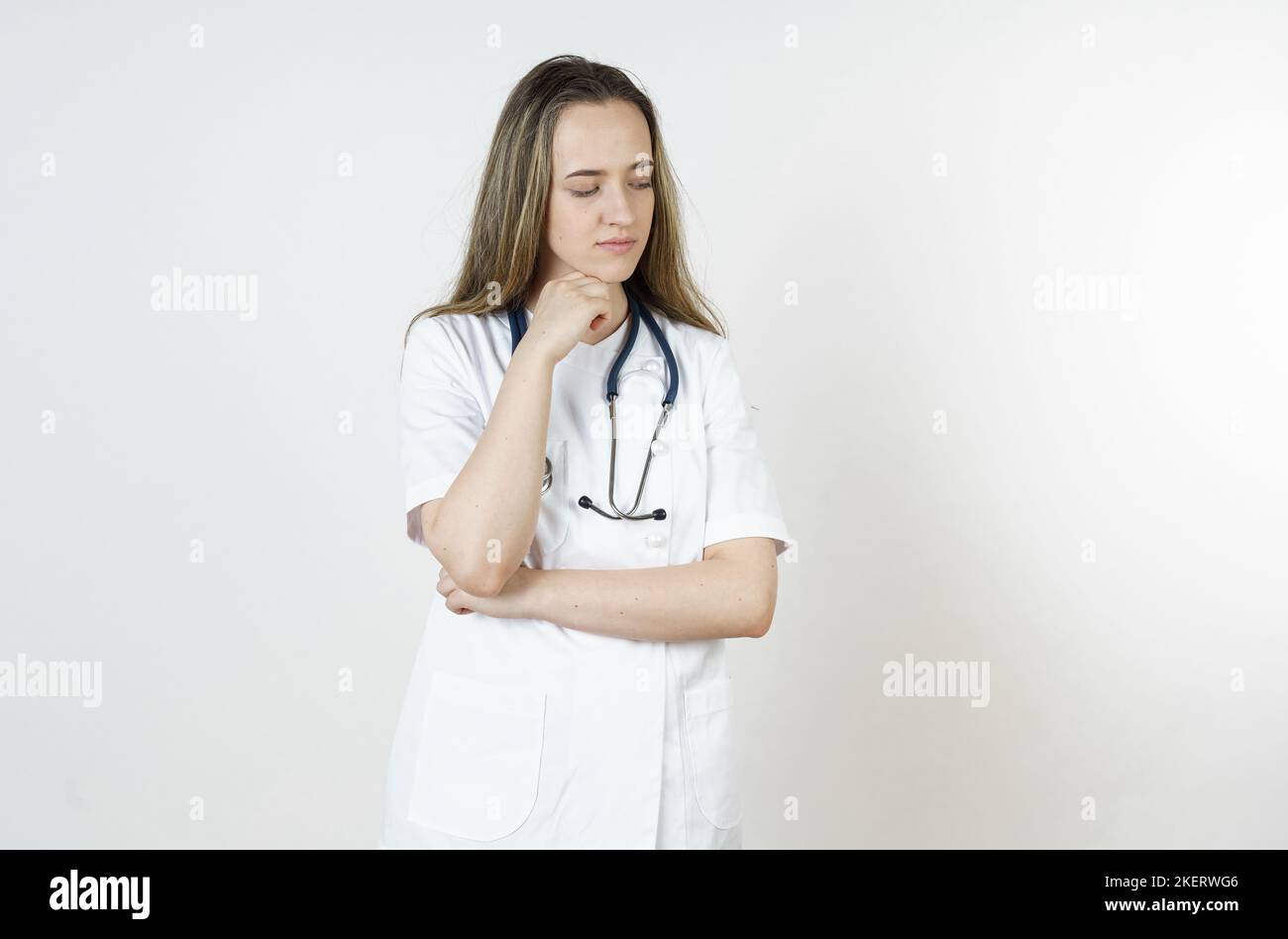 Medicine and health concept. A young woman doctor is thinking, dreaming ...