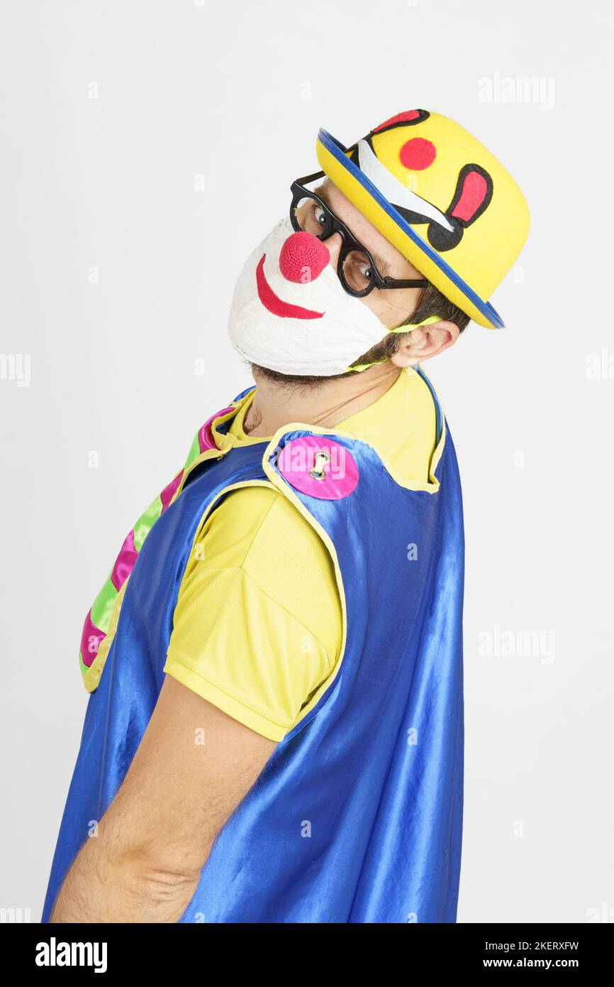 Holiday concept. Portrait of a clown in a bright blue and yellow suit ...