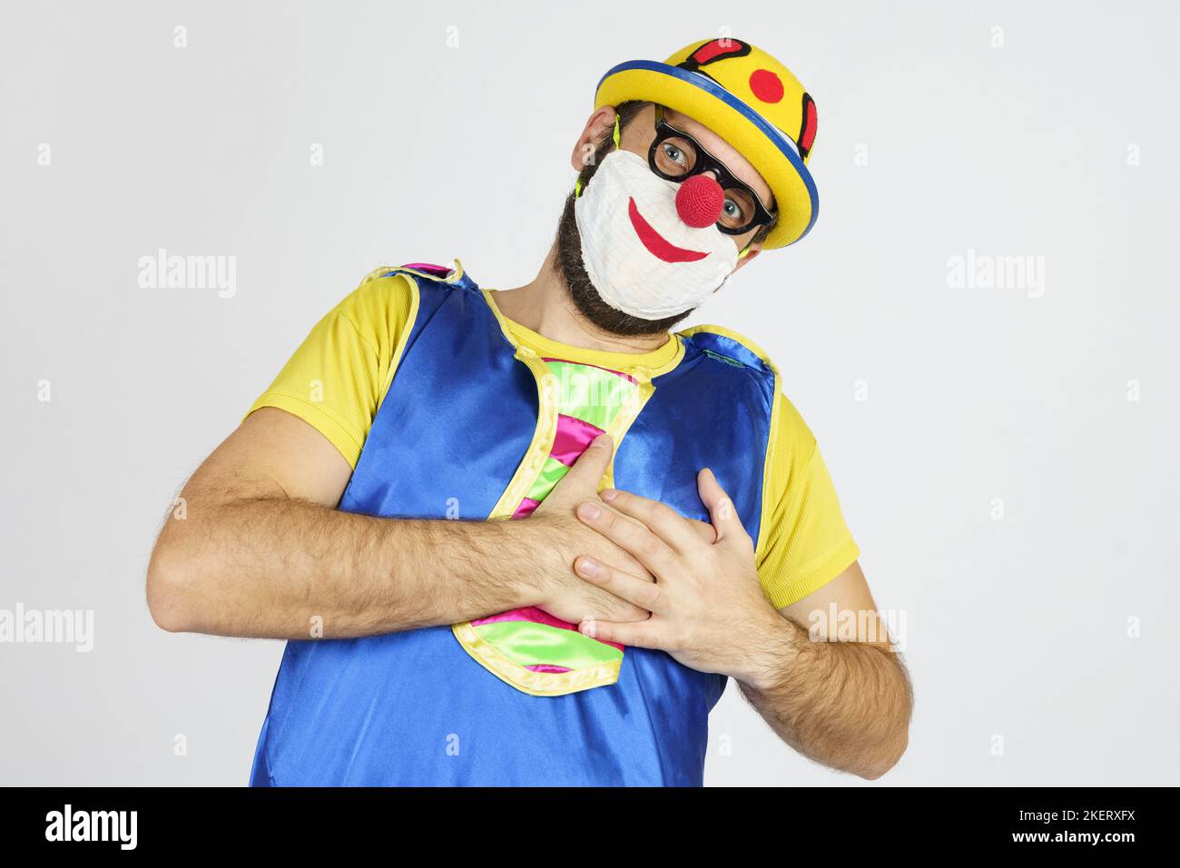 Holiday concept. A clown in a bright blue and yellow suit and mask ...