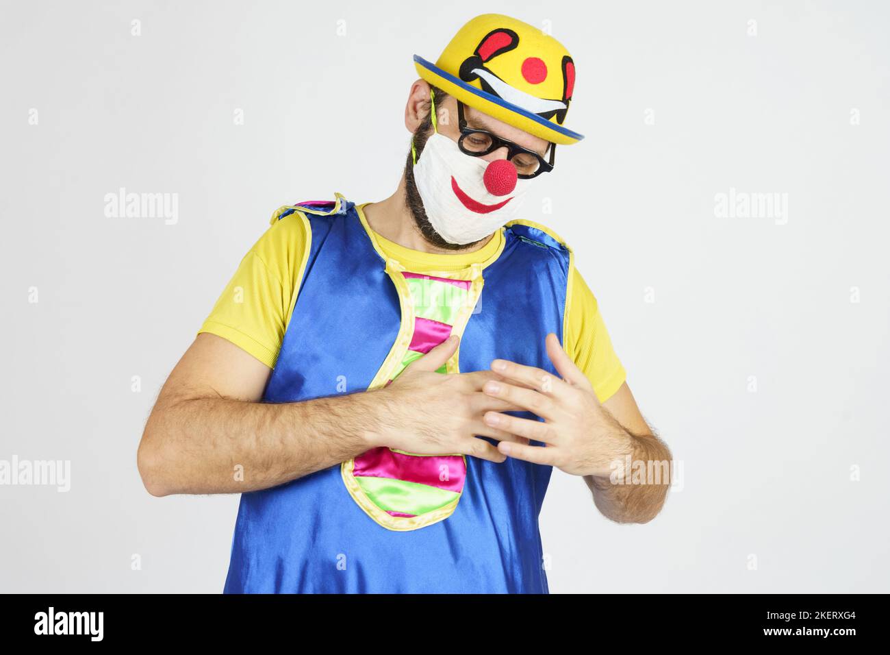 Holiday concept. A clown in a bright blue and yellow suit and mask ...