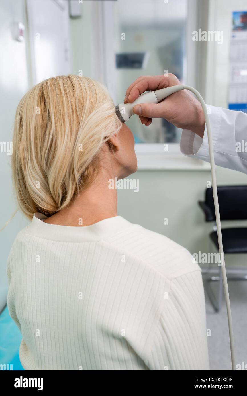 back view of blonde woman near physician doing neurological diagnostics ...