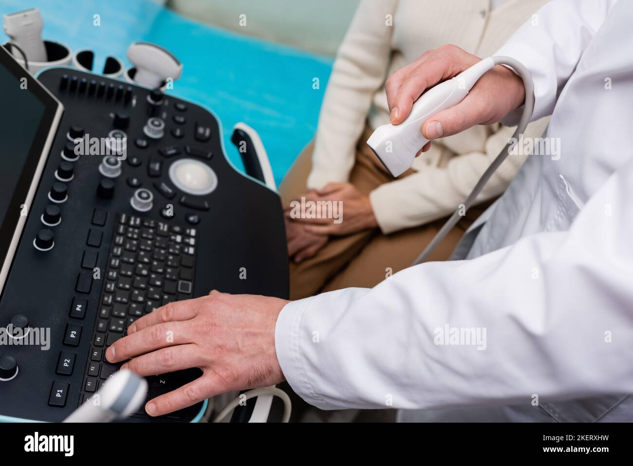 partial view of doctor using console of ultrasound machine near woman ...