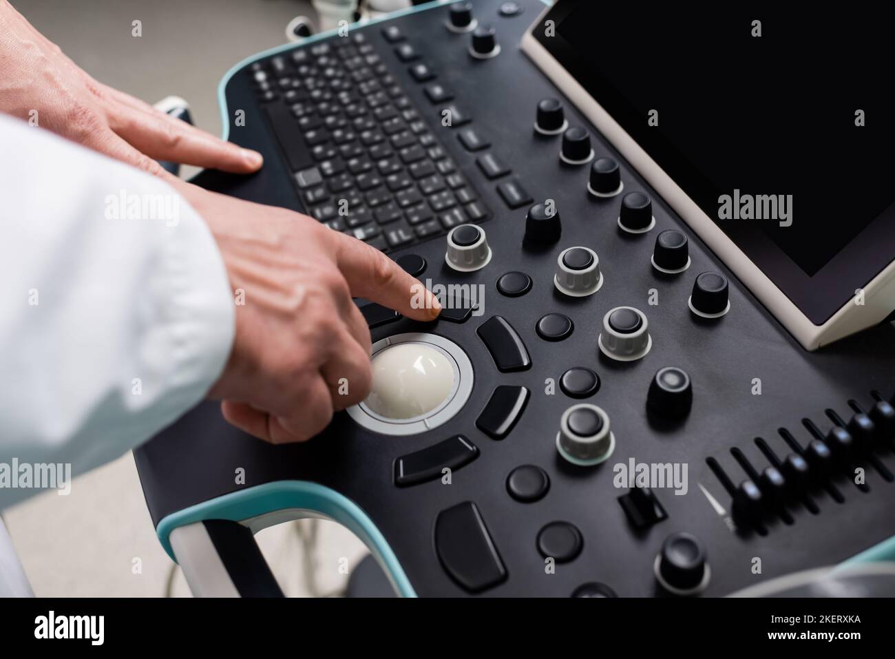partial view of physician using control panel of ultrasound machine ...
