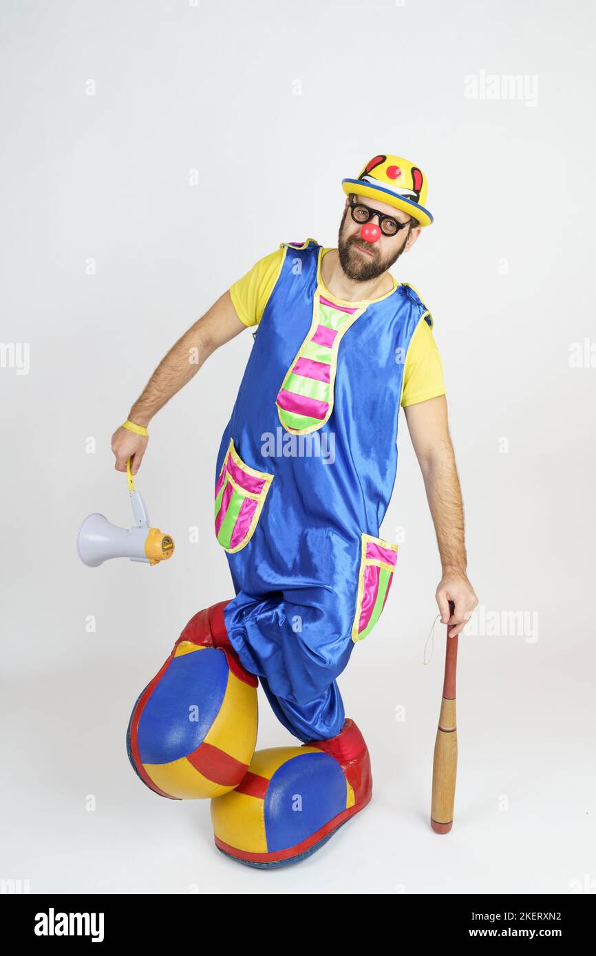 Holiday concept. The clown is a man in a bright blue and yellow suit ...