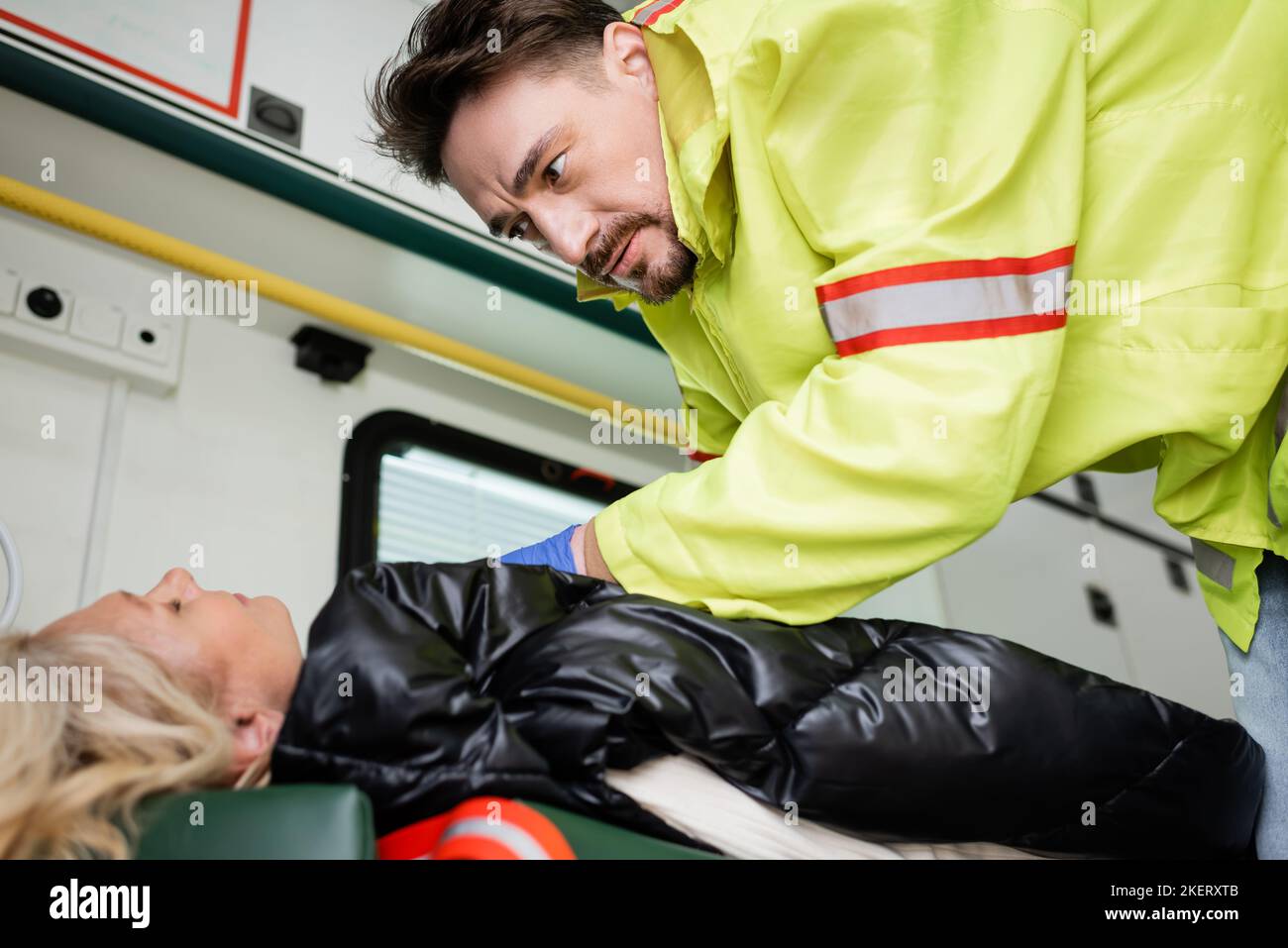 Paramedic in uniform giving first aid to unconscious patient in ...