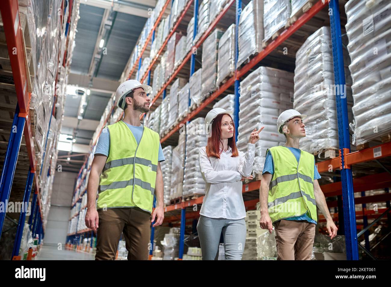Team of warehouse employees conducting a racking system inspection ...