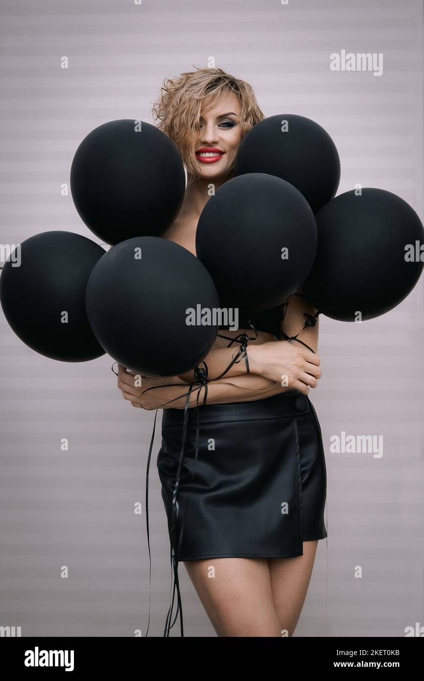 Beautiful woman of model appearance with dark balloons. Art shooting ...