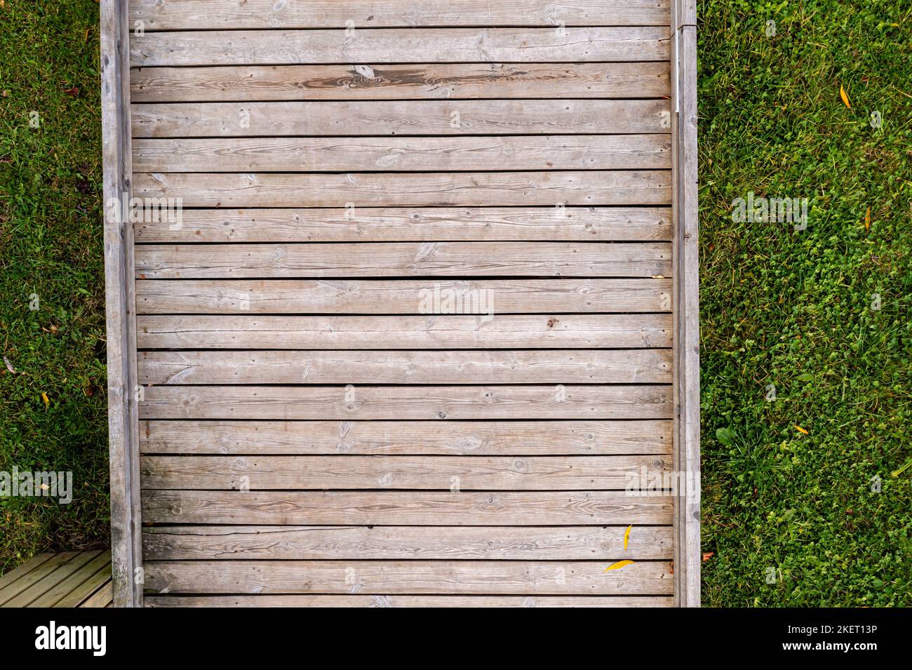 wooden boardwalk over lawn with green grass, modern park background ...