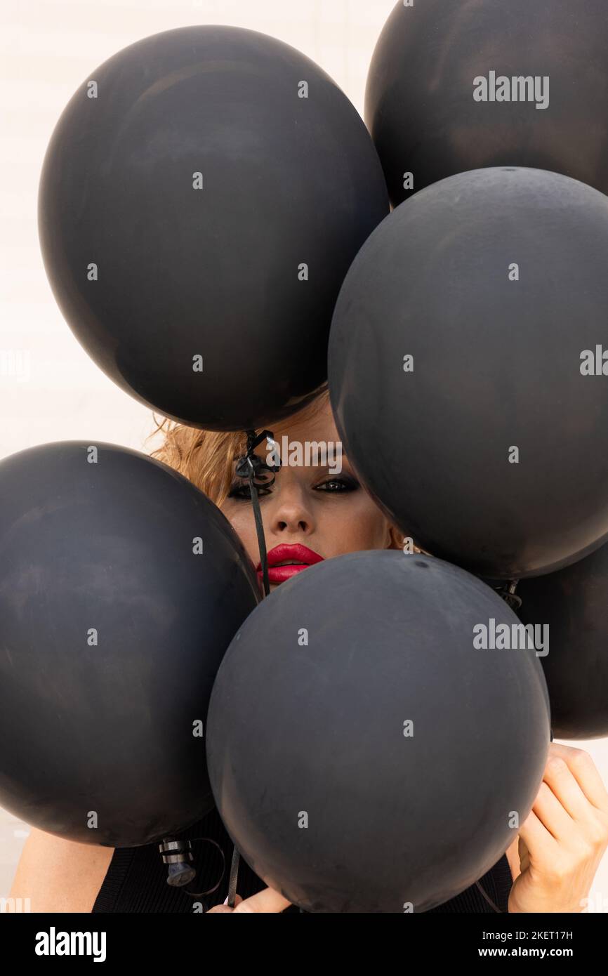 Beautiful woman of model appearance with dark balloons. Art shooting ...