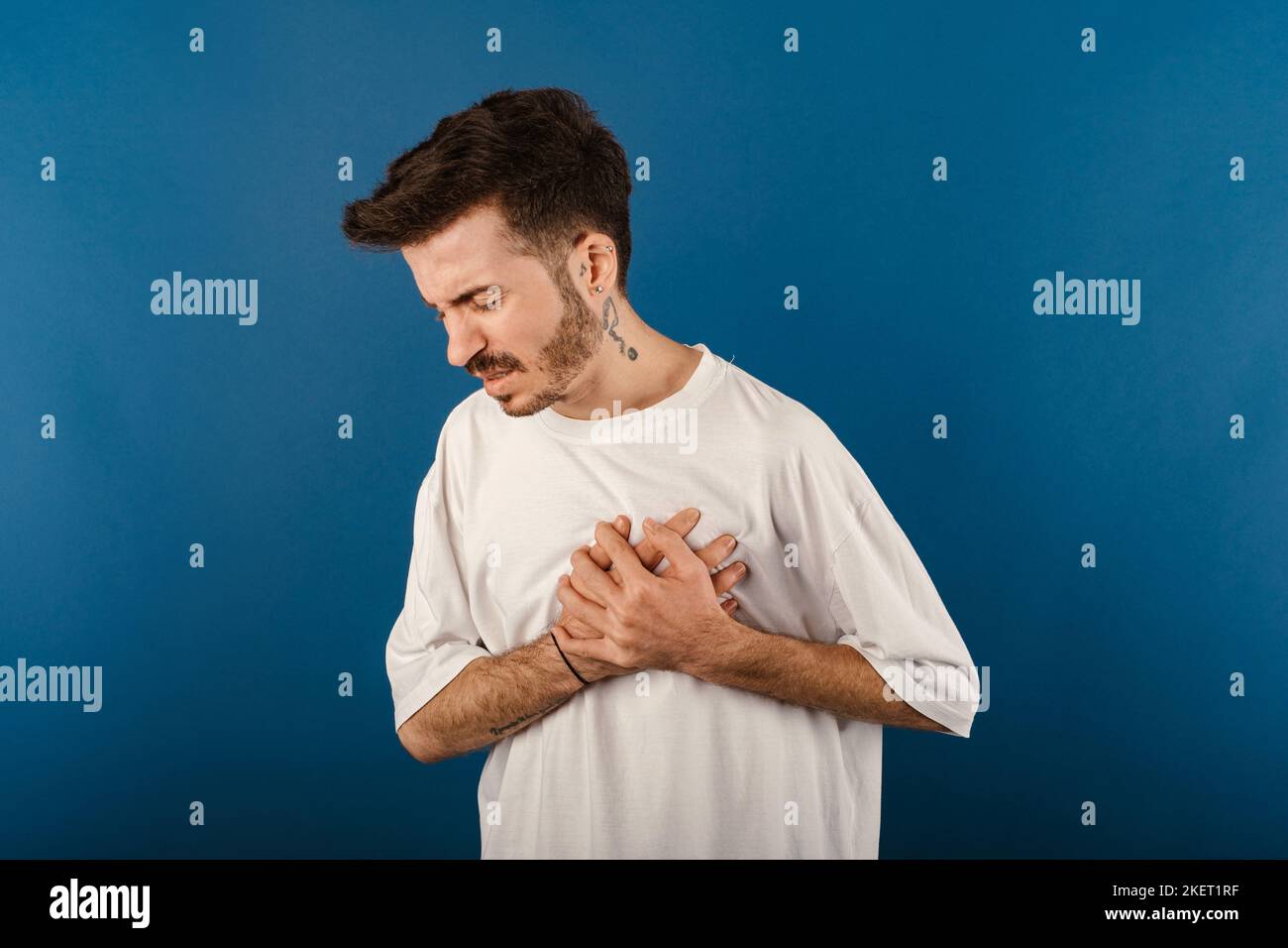 Caucasian man wearing white tee posing isolated over blue background ...