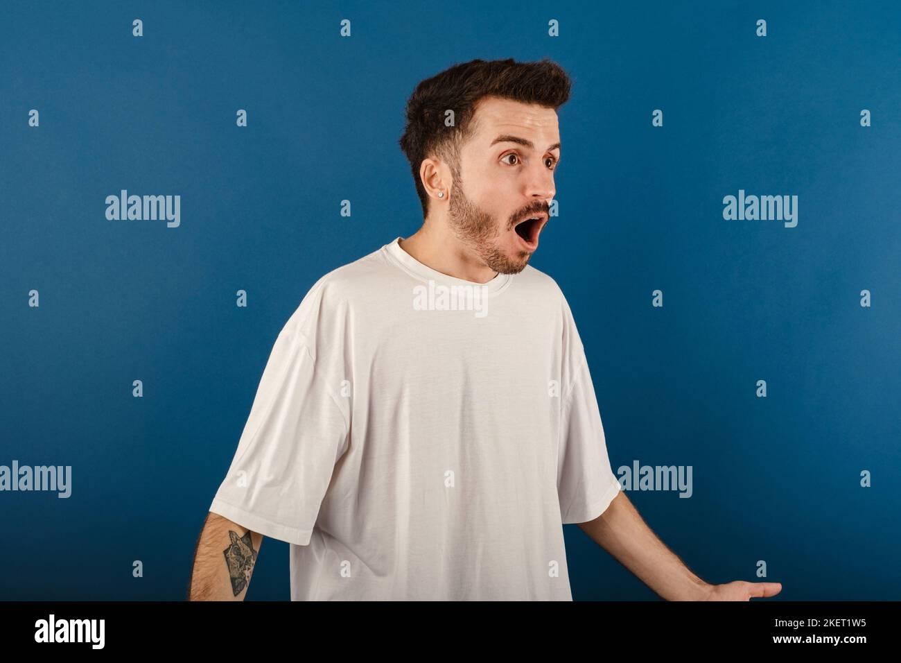 Caucasian young man wearing t-shirt posing isolated over blue ...