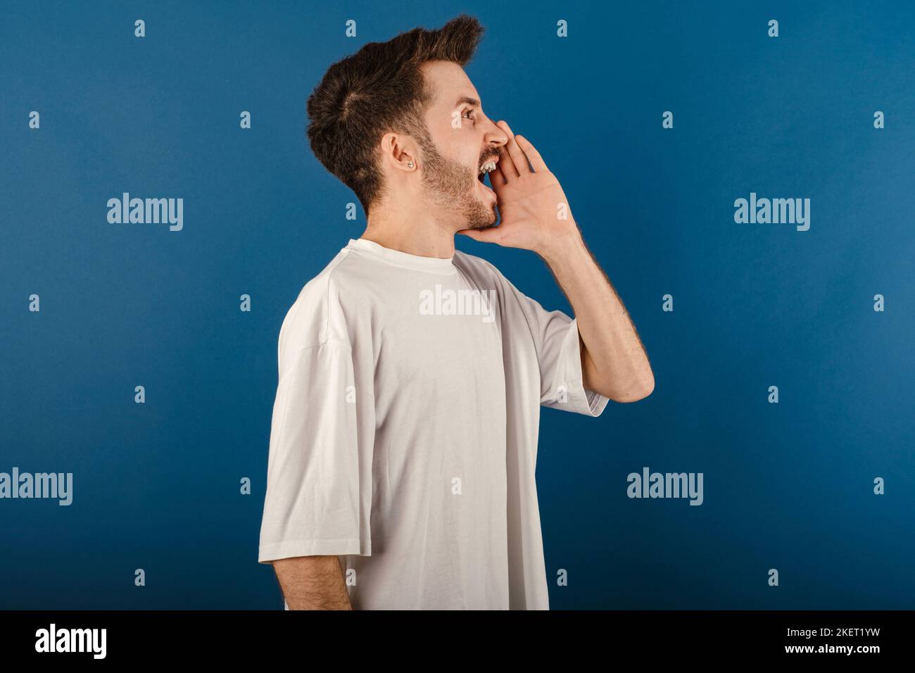 Caucasian young man wearing t-shirt posing isolated over blue ...