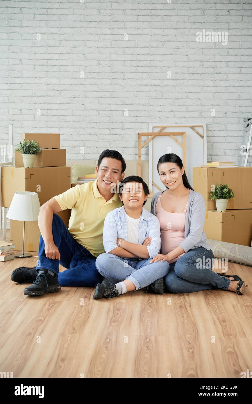 Full length portrait of cheerful Asian family of three posing for ...
