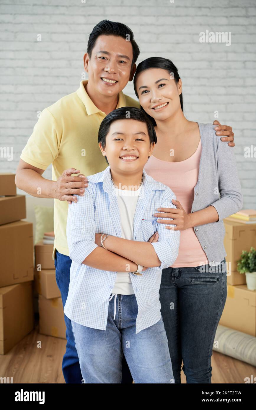Happy Asian family distracted from packing stuff in cardboard boxed in ...