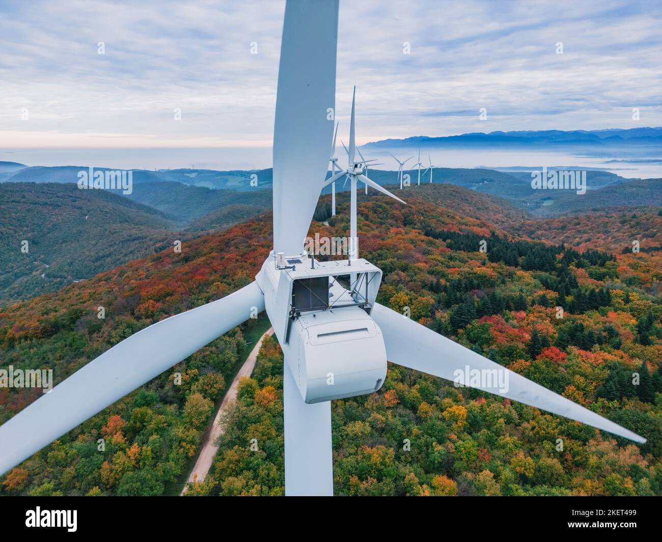 Close-up on the propellers of a wind turbine during a misty morning and ...