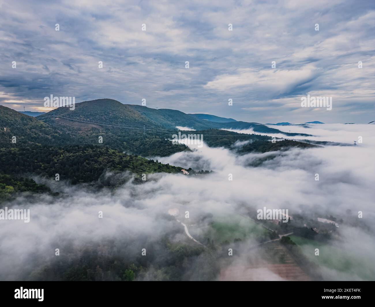Thick morning fog covering the valley between the surrounding mountains ...