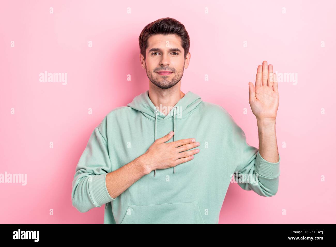 Portrait of calm peaceful young person arm touch heart raise palm swear ...