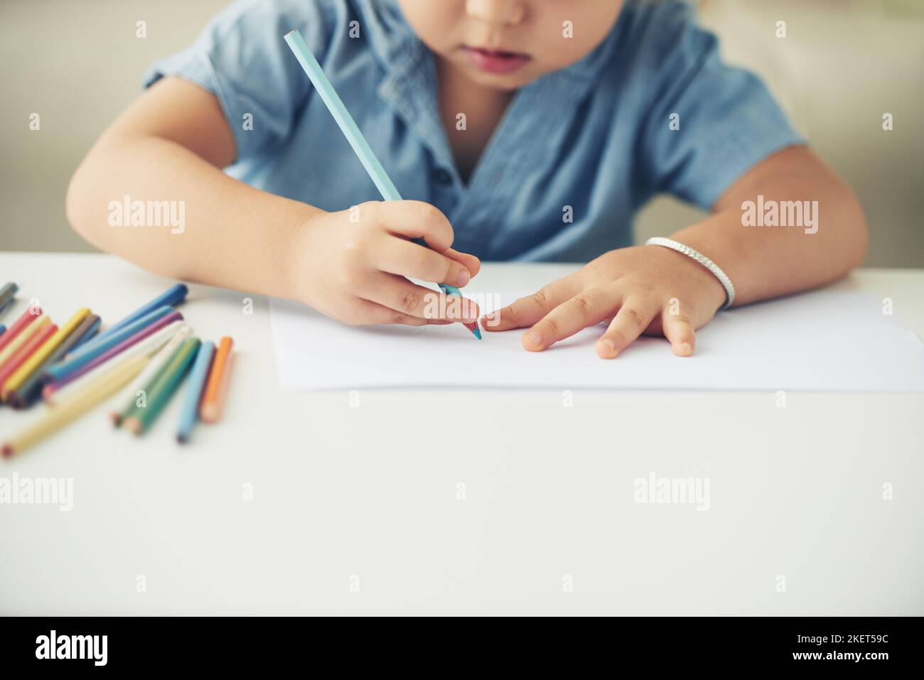 Close-up image of girl drawing with blue pencil Stock Photo - Alamy