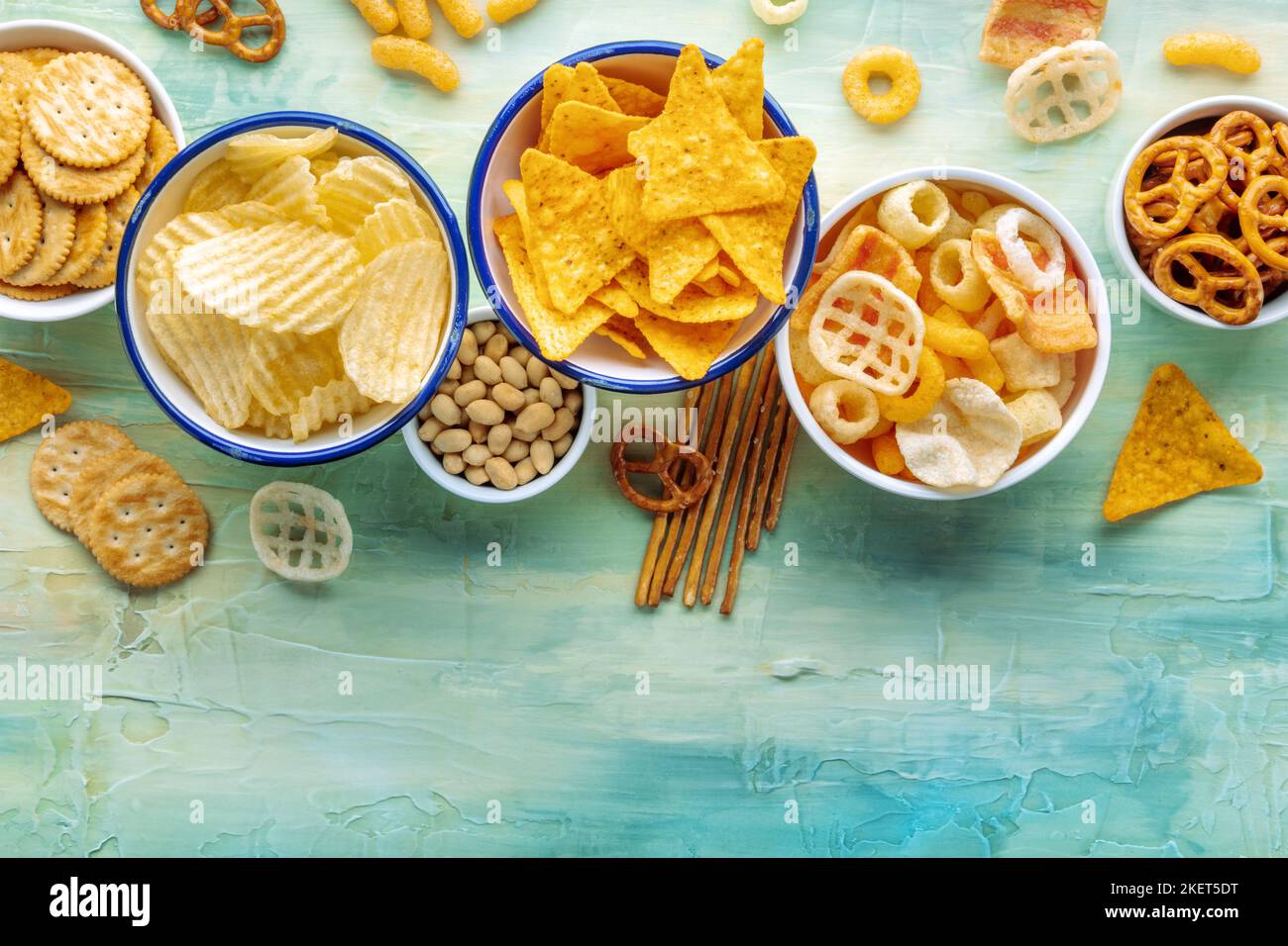 Potato and tortilla chips and other salty snacks, shot from above with ...