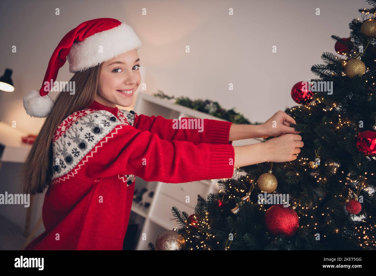 Photo of positive pretty lady decorating pine spruce hanging ball ...