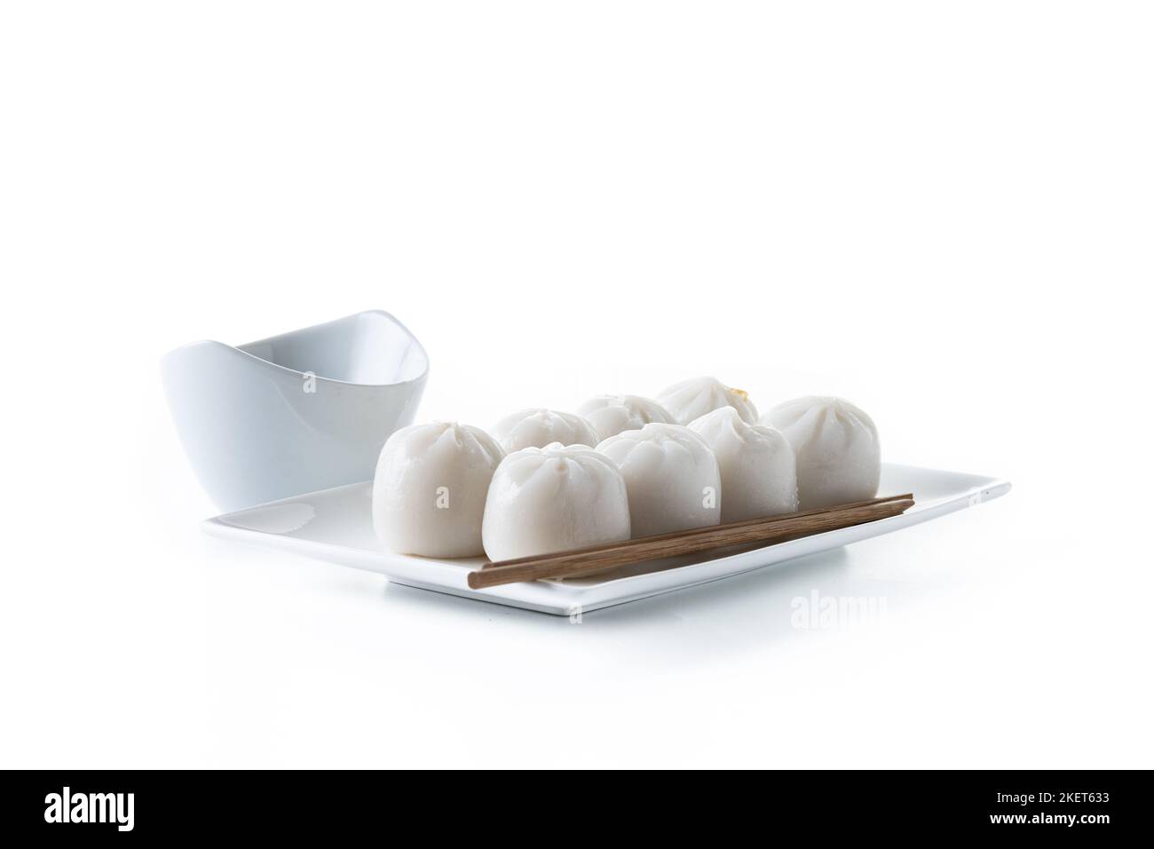 Steamed dumplings on plate and soy sauce isolated on white background ...