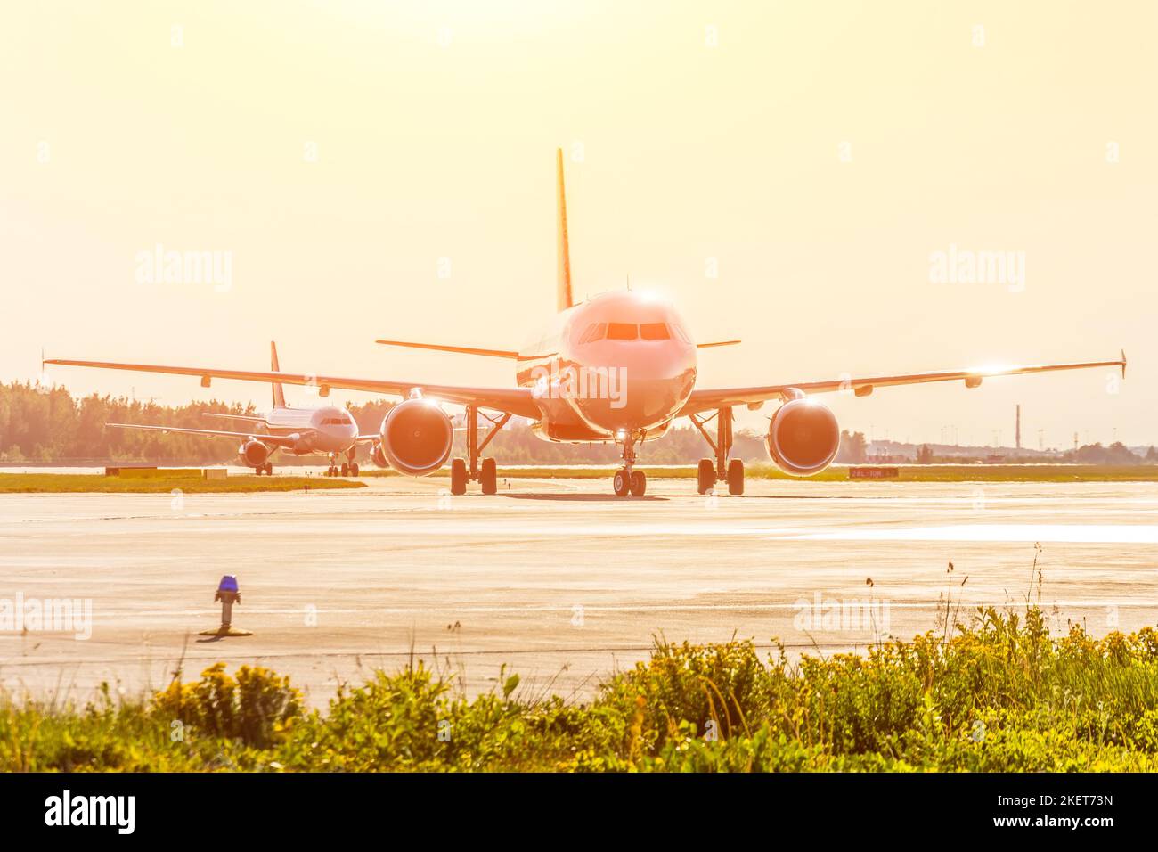 Two passenger aircraft on taxi to the terminal after landing, bright ...